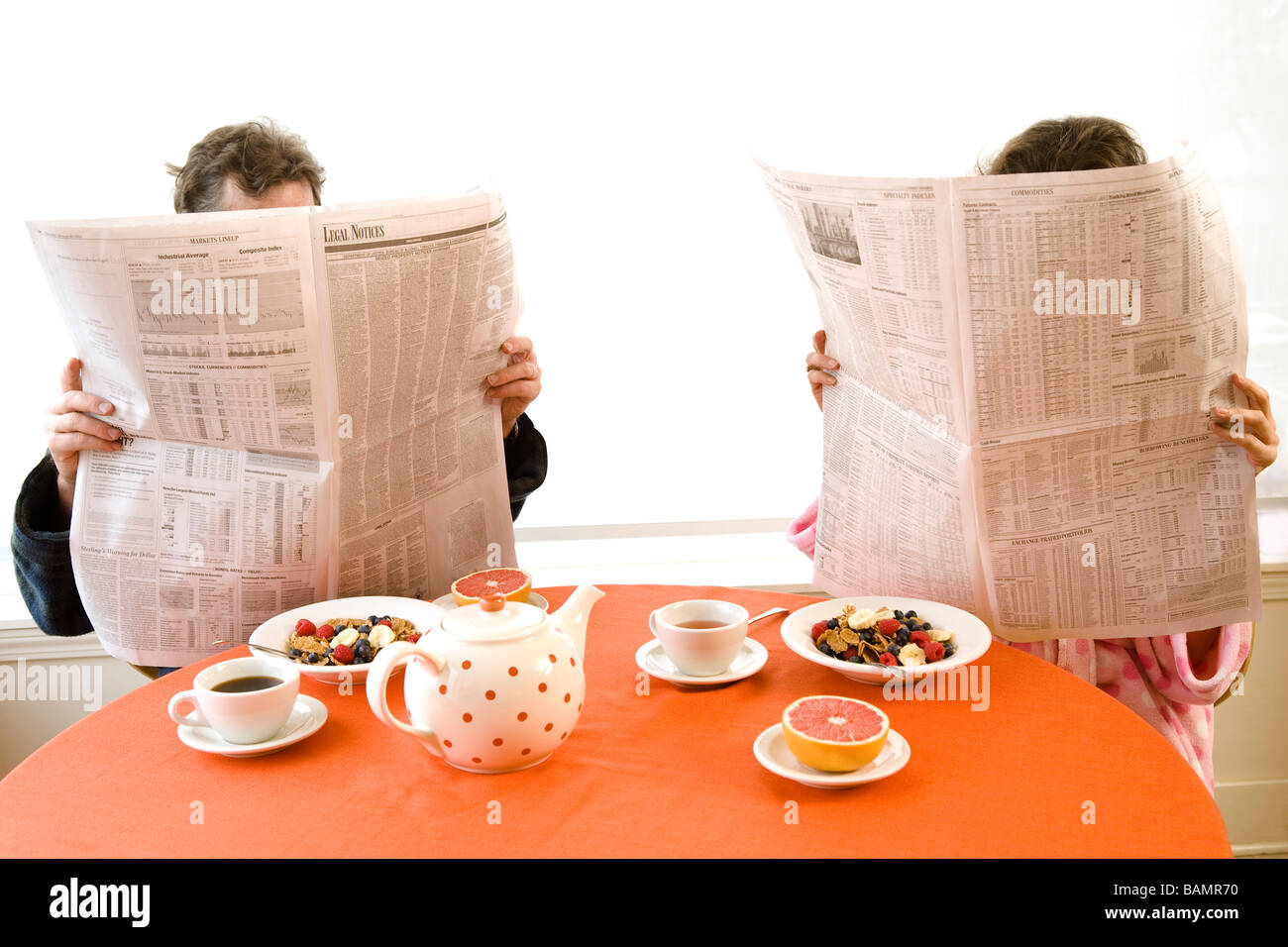 Man and woman at breakfast table with newspapers Stock Photo - Alamy