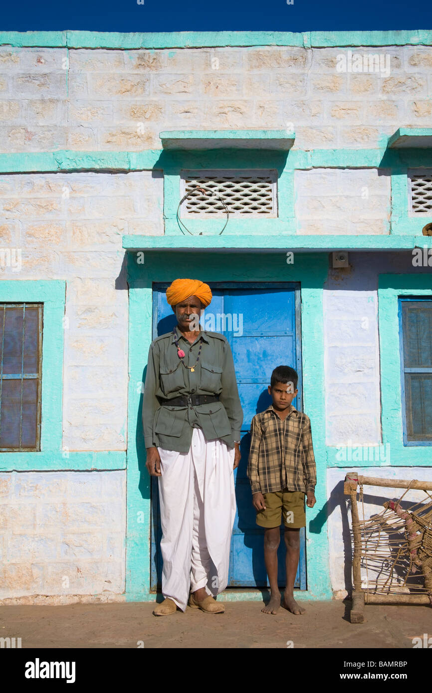 Man and boy standing outside a colourful painted house near Osian ...