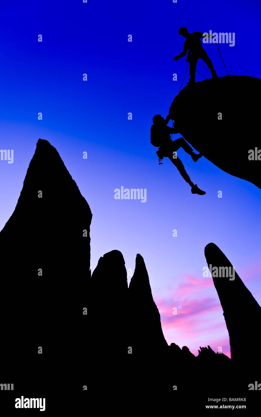 Team of climbers reaching the summit of a rock pinnacle in The Sierra ...