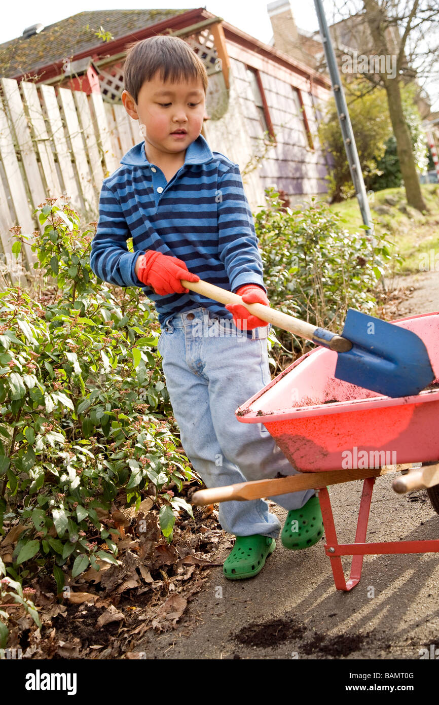 Young boy working in garden Stock Photo - Alamy