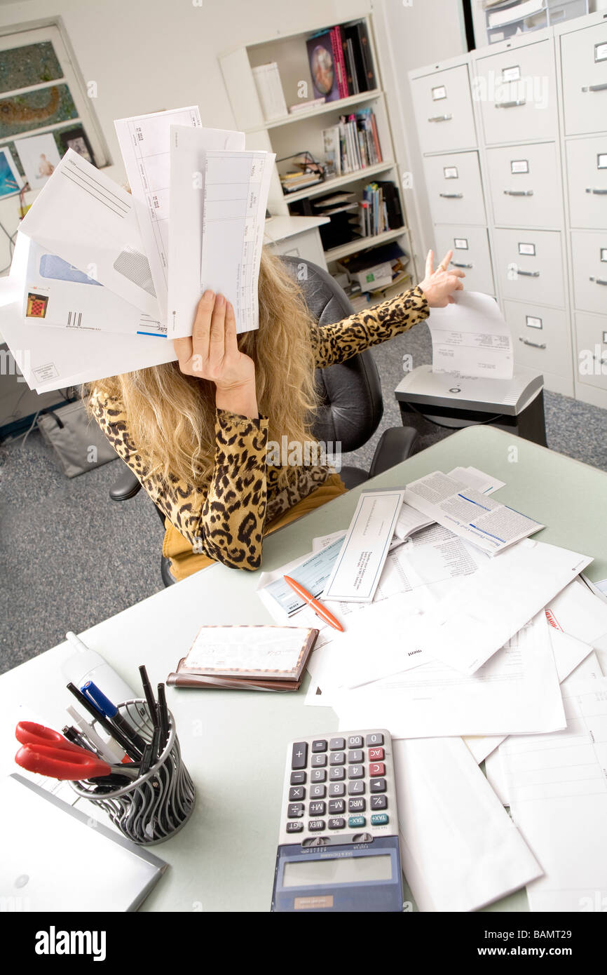Woman sorting through bills and mail in an office Stock Photo - Alamy