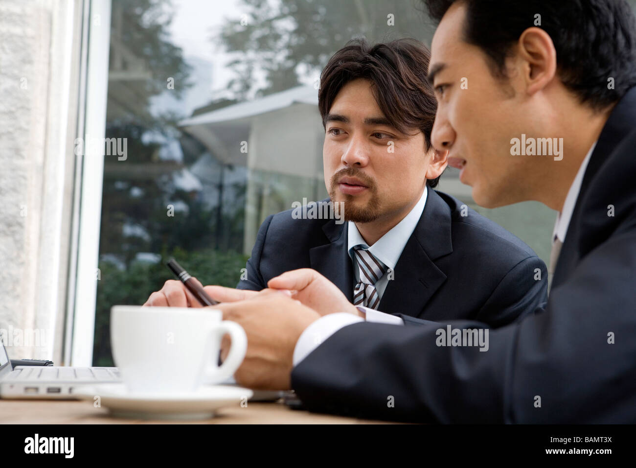 Two Businessmen Having A Meeting At A Cafe Stock Photo - Alamy