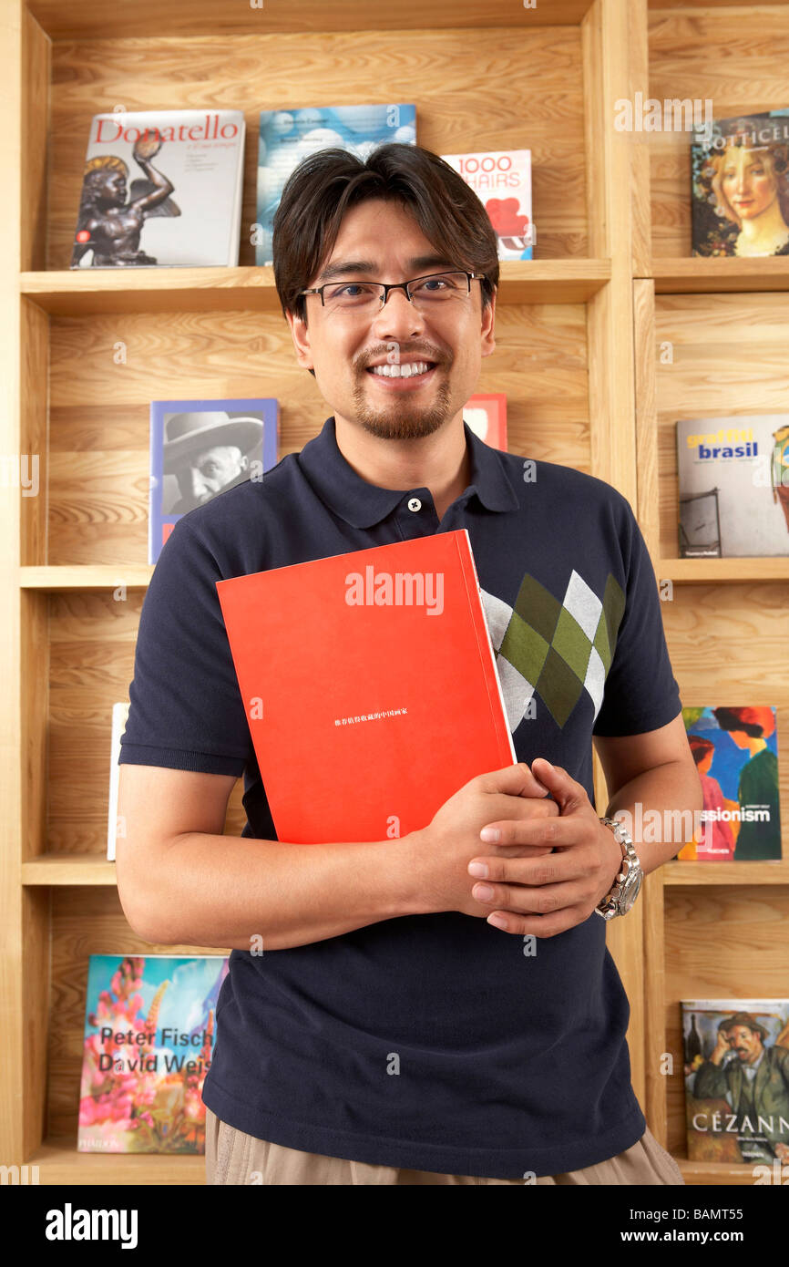 Man Holding Book At Library Stock Photo - Alamy