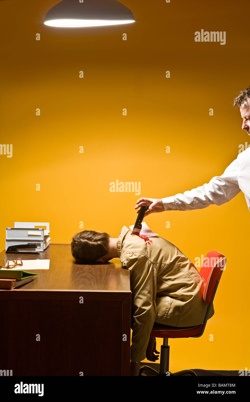 Stabbed in the back at the office Stock Photo - Alamy