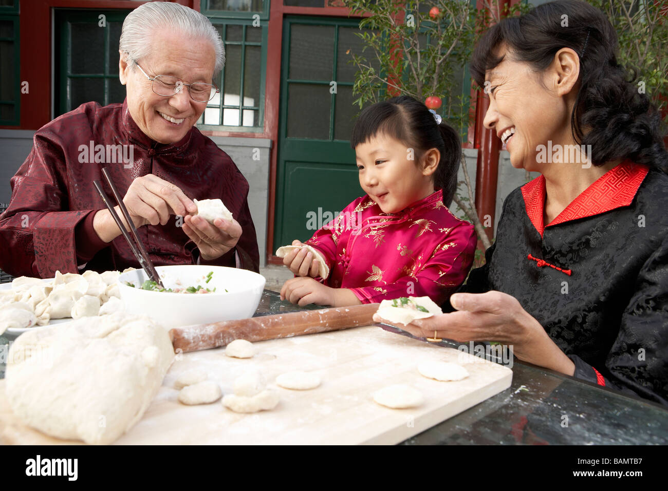 Family Making Dumplings In Courtyard Stock Photo - Alamy