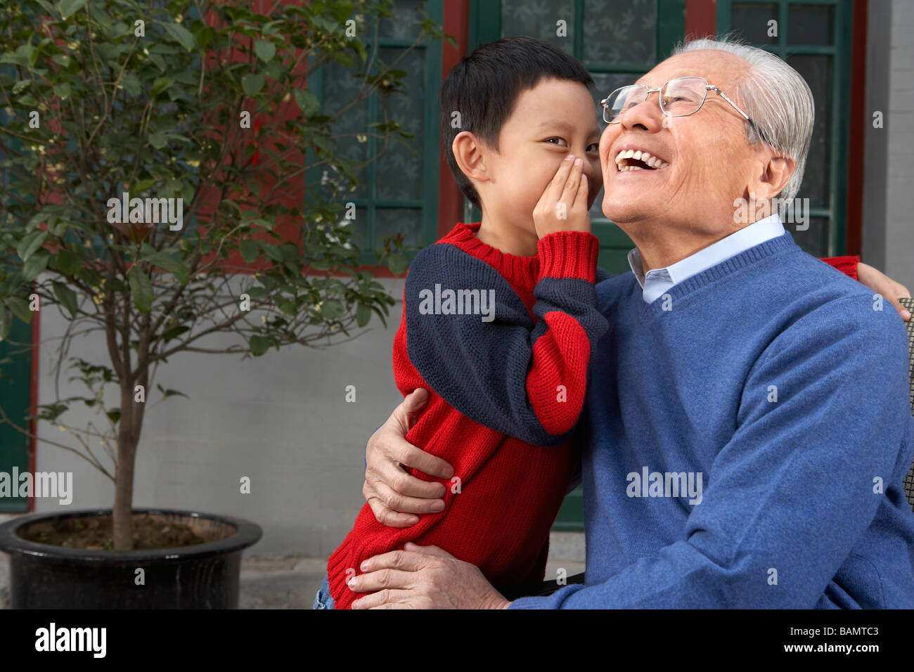 Young Boy Whispering Into Grandfather' Ear Stock Photo - Alamy