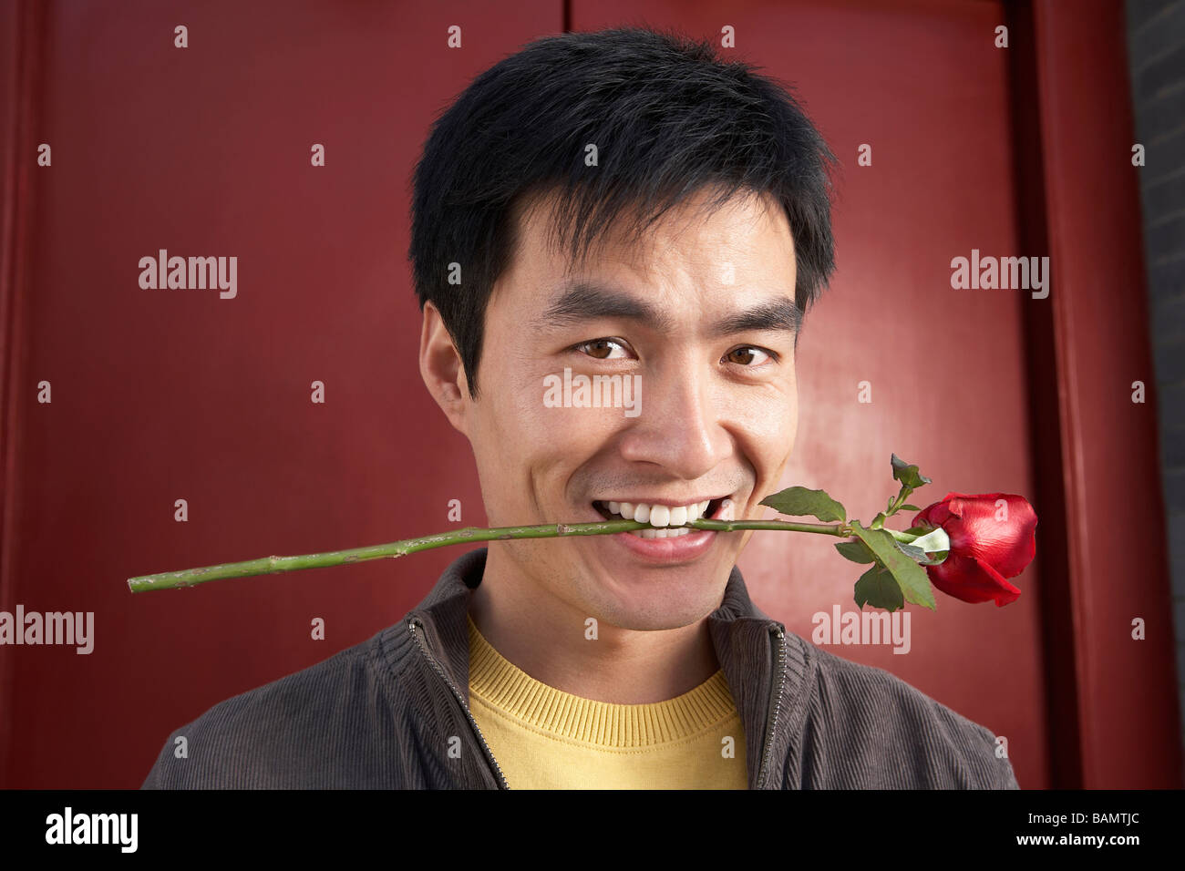 Young Man Waiting Outside Front Door Holding A Rose In His Mouth Stock ...