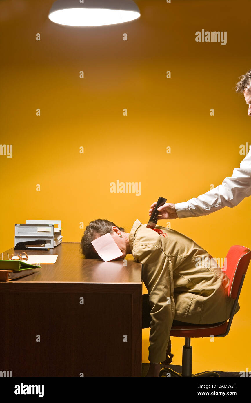 Stabbed in the back at the office Stock Photo - Alamy