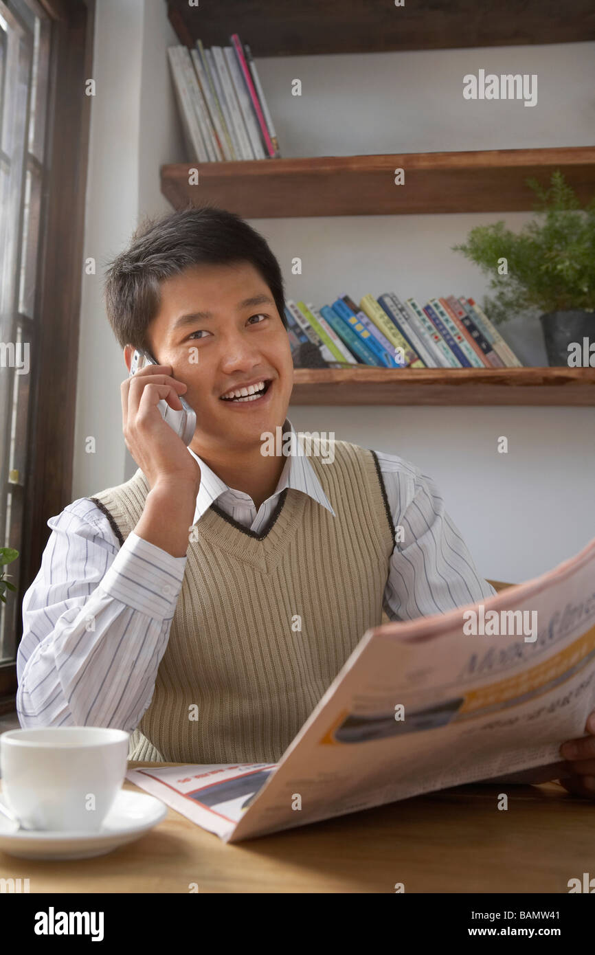 Man Talking On Cellphone Holding A Newspaper Stock Photo - Alamy