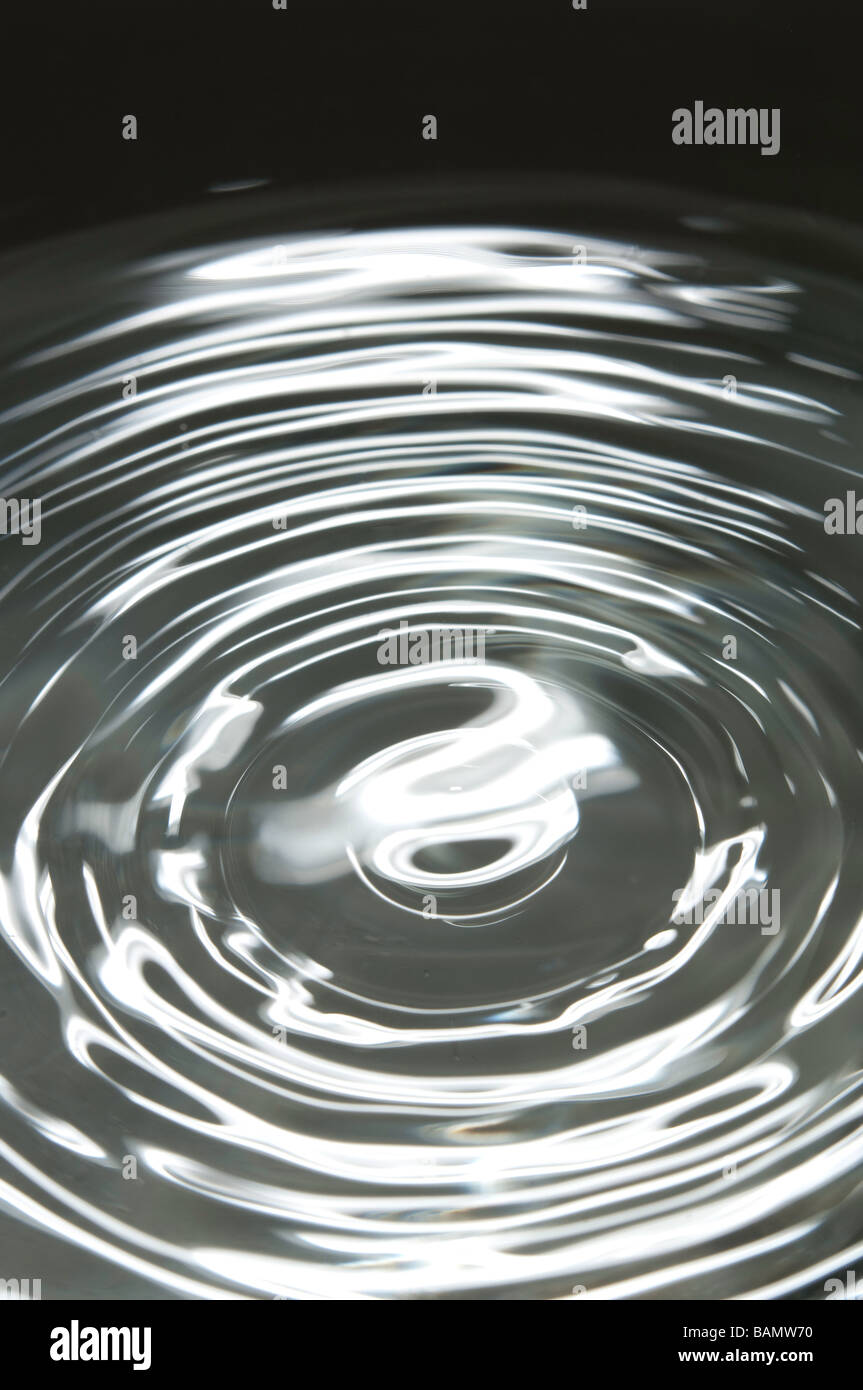 Droplet causing ripples on surface of a pool of water Stock Photo - Alamy