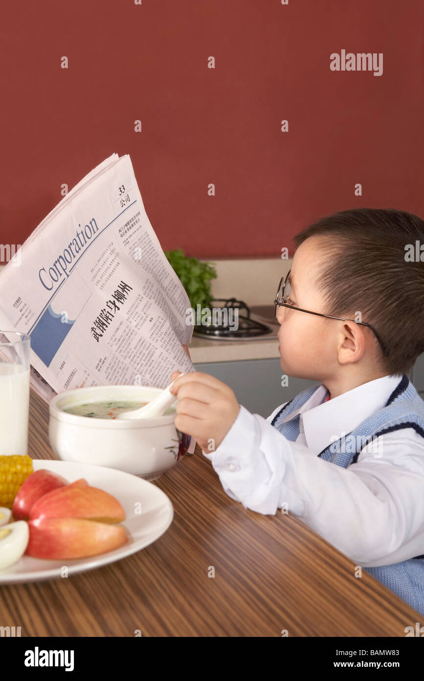 Young boy reading a business newspaper at the breakfast table Stock ...