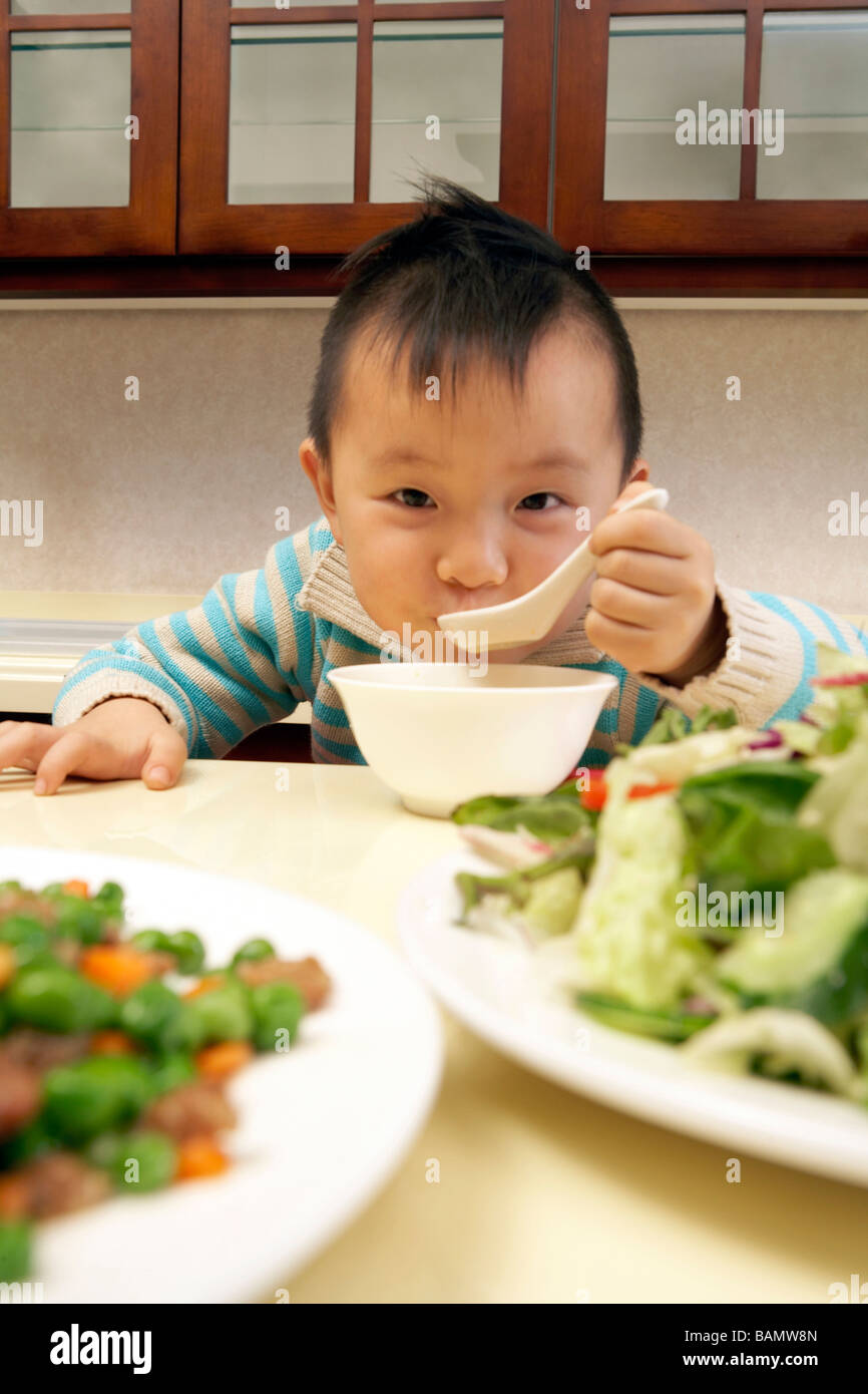 Young boy happily eating soup Stock Photo - Alamy