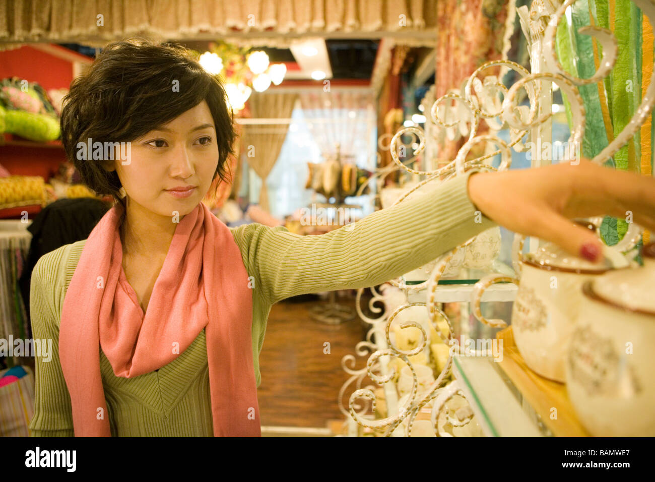 Young Woman Looking At Objects In Shop Stock Photo - Alamy