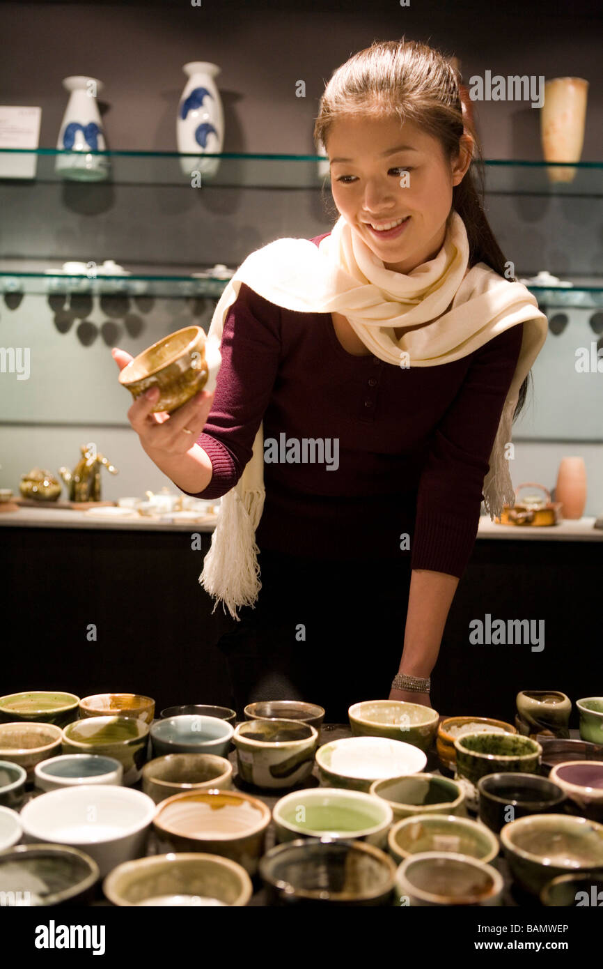 Young Woman Looking At Objects In Shop Stock Photo - Alamy