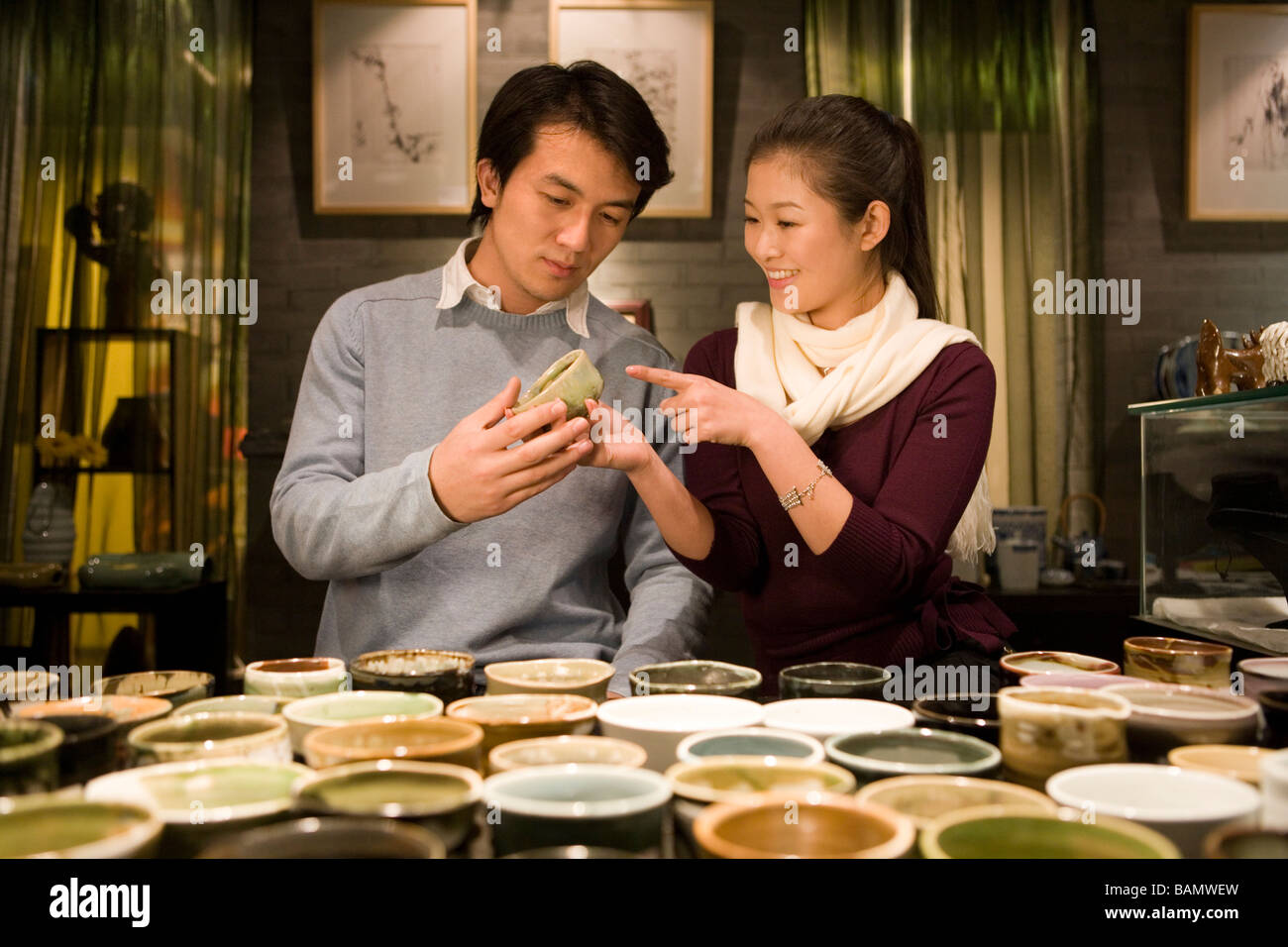Young Couple Looking At Objects In Shop Stock Photo - Alamy