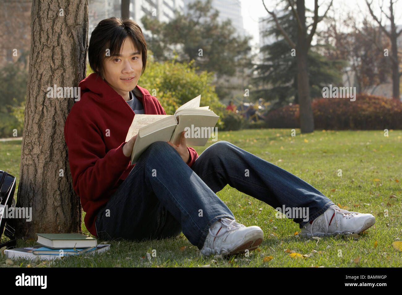 Young Man Reading Book In The Park Stock Photo - Alamy