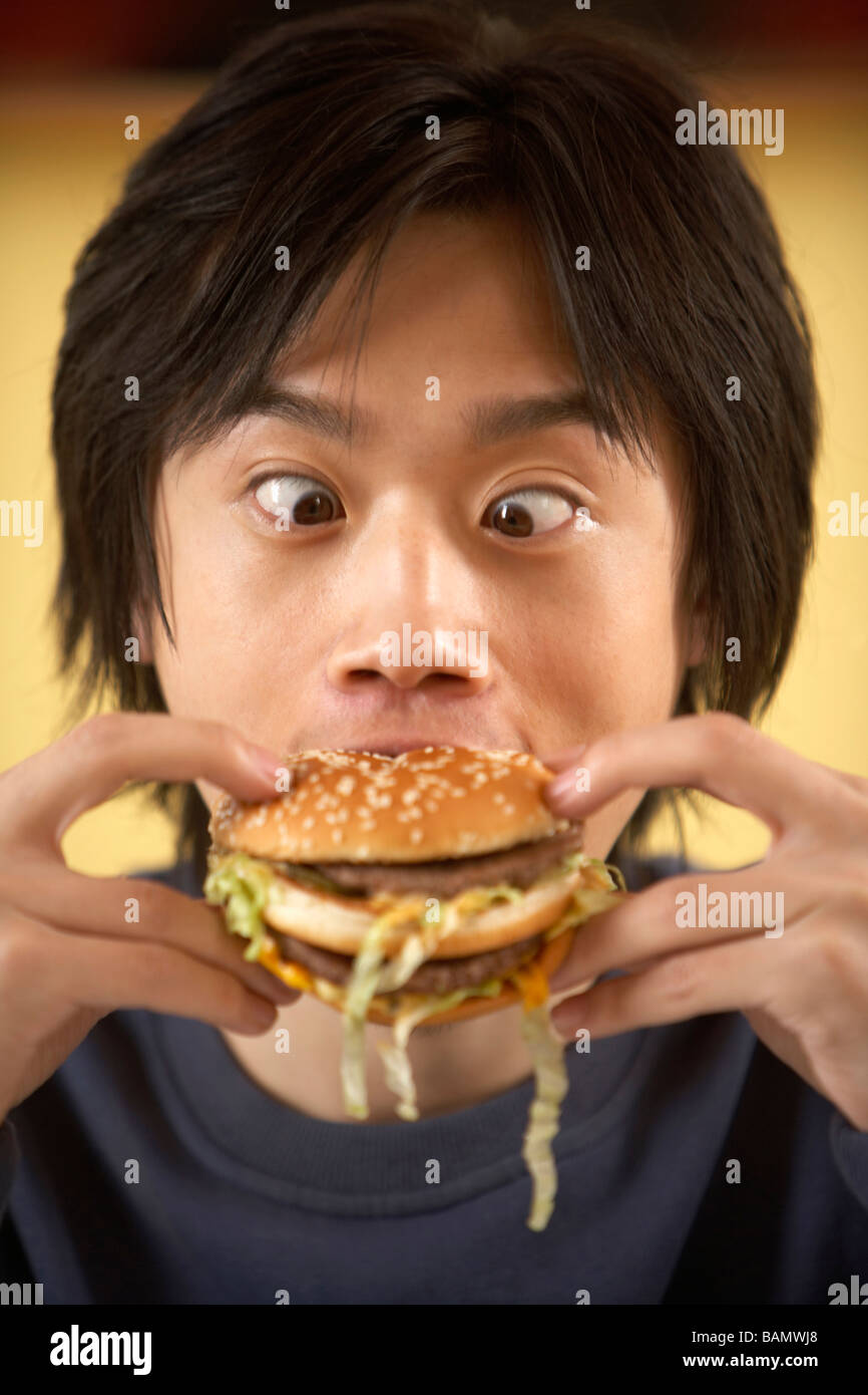 Teenage Boy Eating Hamburger Stock Photo - Alamy