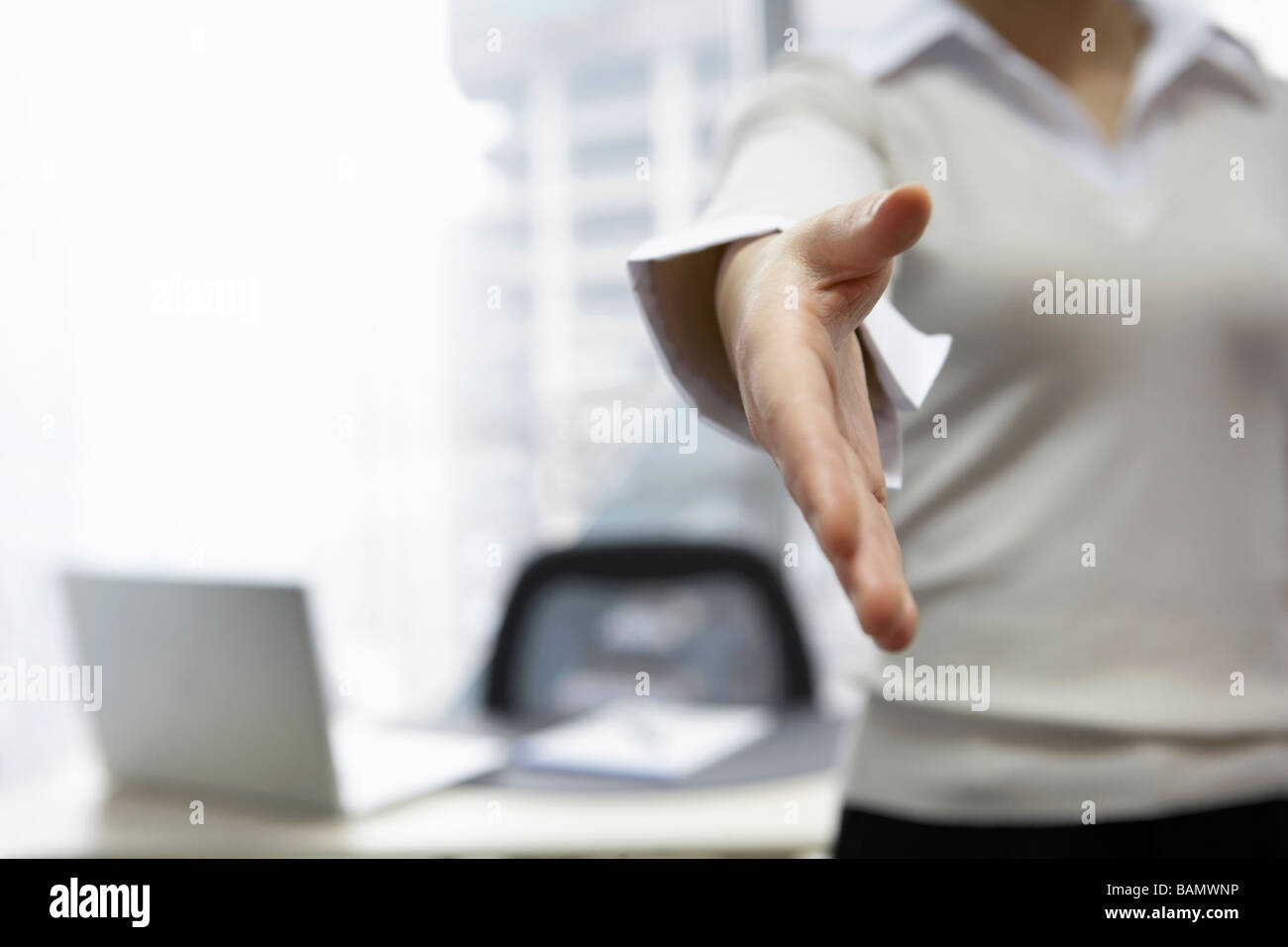 Businesswoman In Office Reaching Out To Shake Hands Stock Photo - Alamy