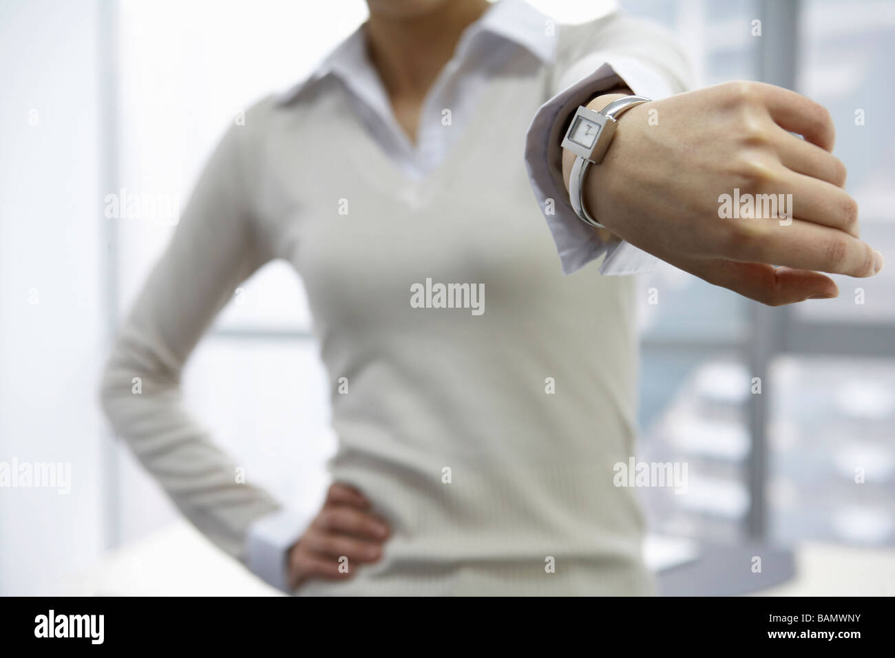 Businesswoman In Office Showing Time On Watch Stock Photo - Alamy
