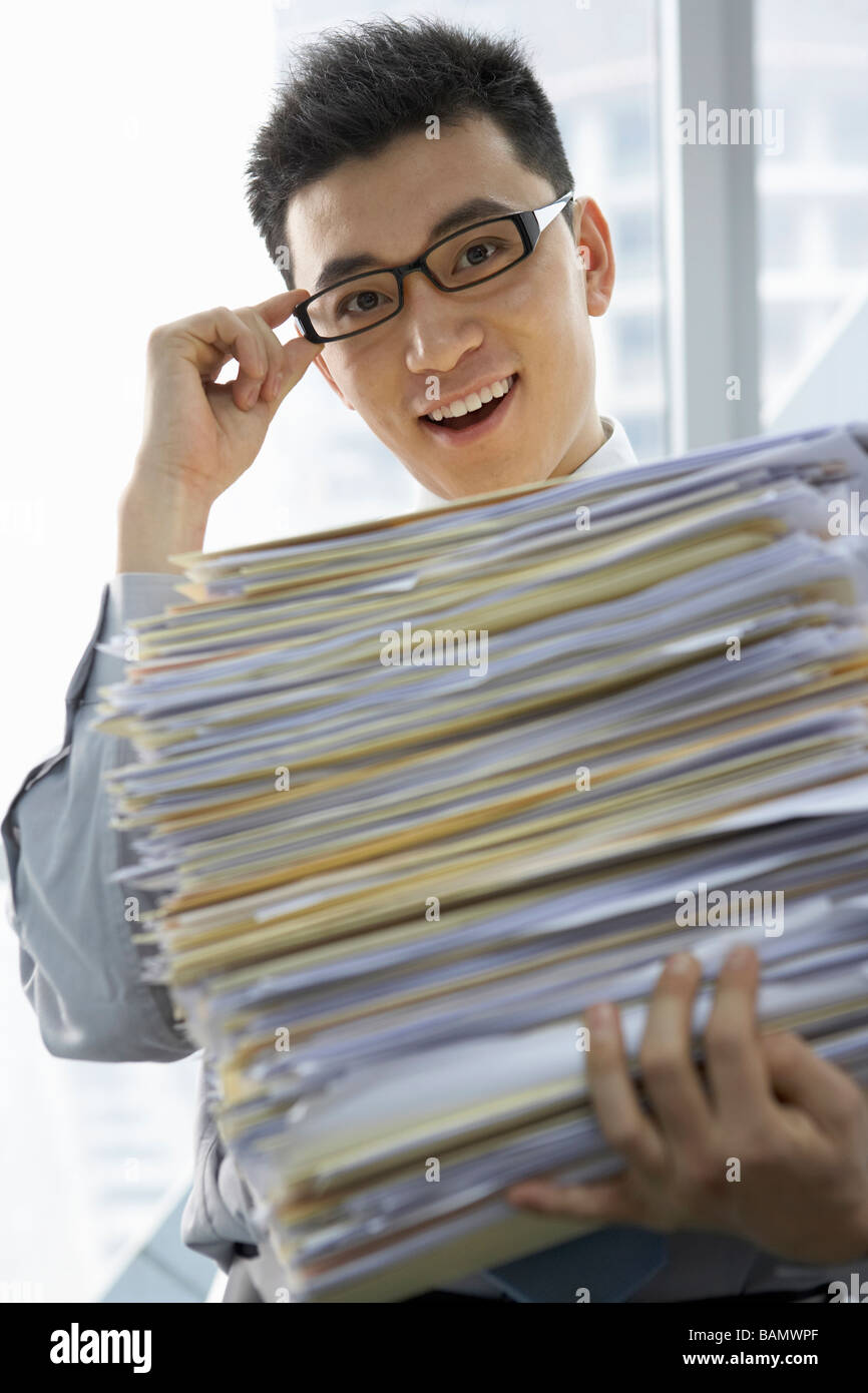 Businessman In Office Holding Pile Of Work Stock Photo - Alamy
