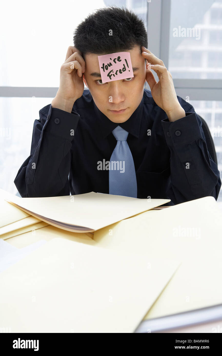 Businessman With Sticky-Note On Forehead And Workpile Stock Photo - Alamy