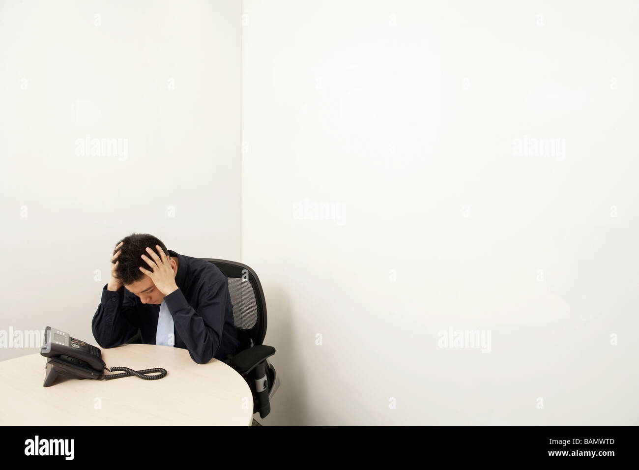 Businessman Sitting Frustrated At Table Stock Photo - Alamy
