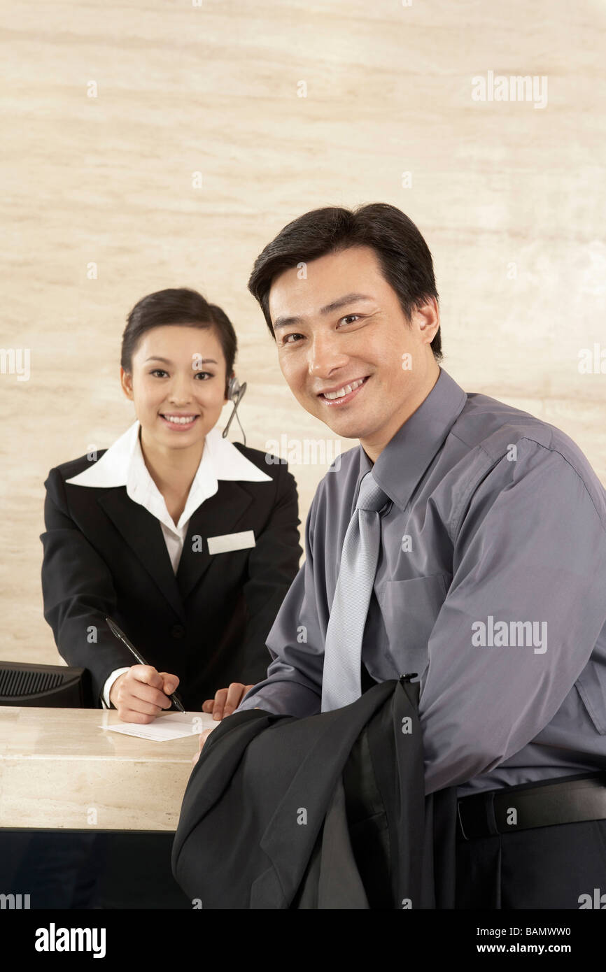Hotel Employee And Client In Reception Stock Photo - Alamy