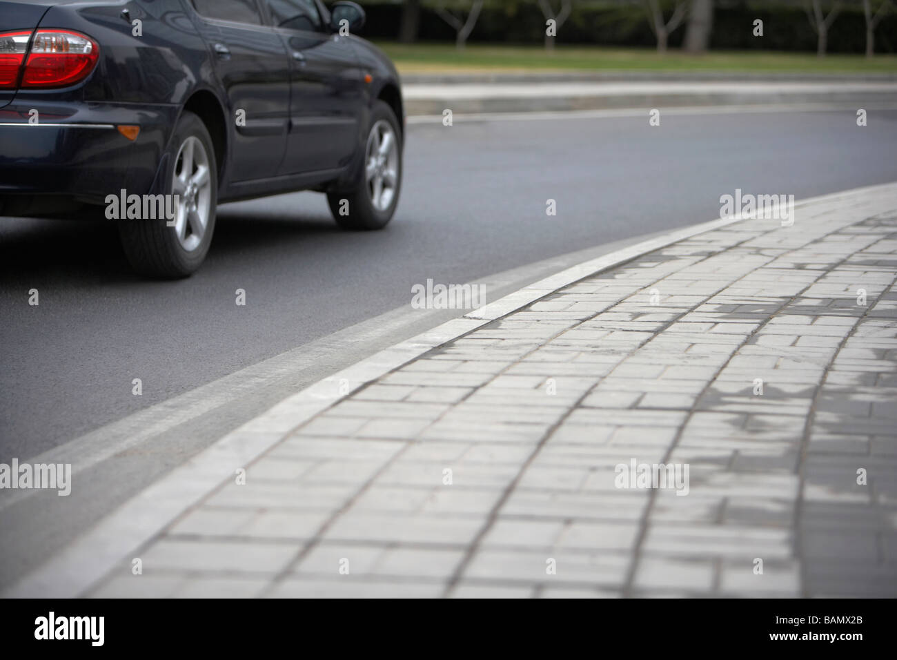 Low Angle View Of A Concrete Block Pavement With A Car Driving Past ...