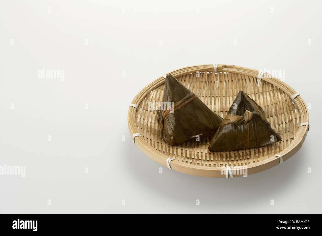Zongzi in a woven bowl Stock Photo - Alamy