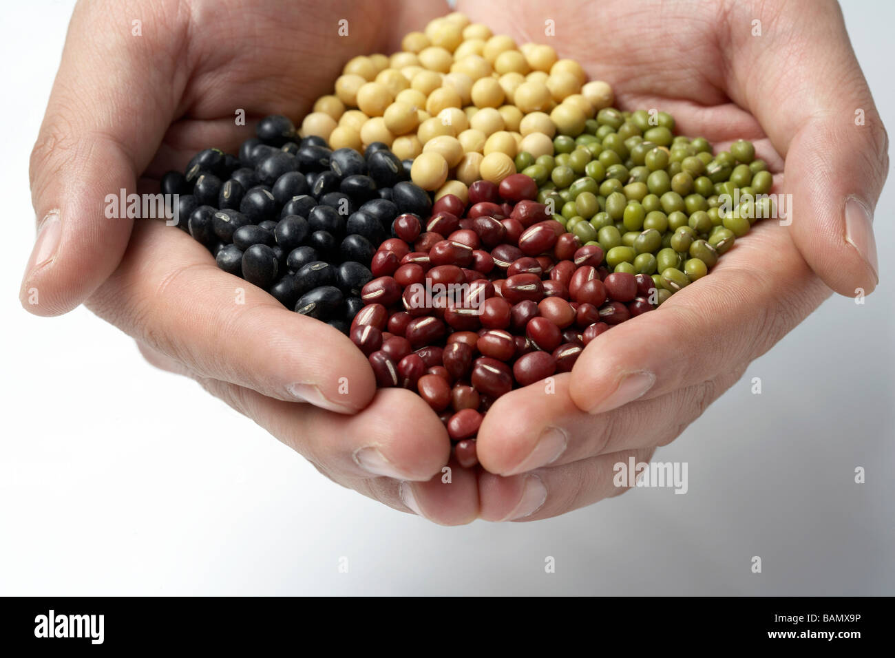 Cupped hands holding multicolored beans and legumes Stock Photo - Alamy