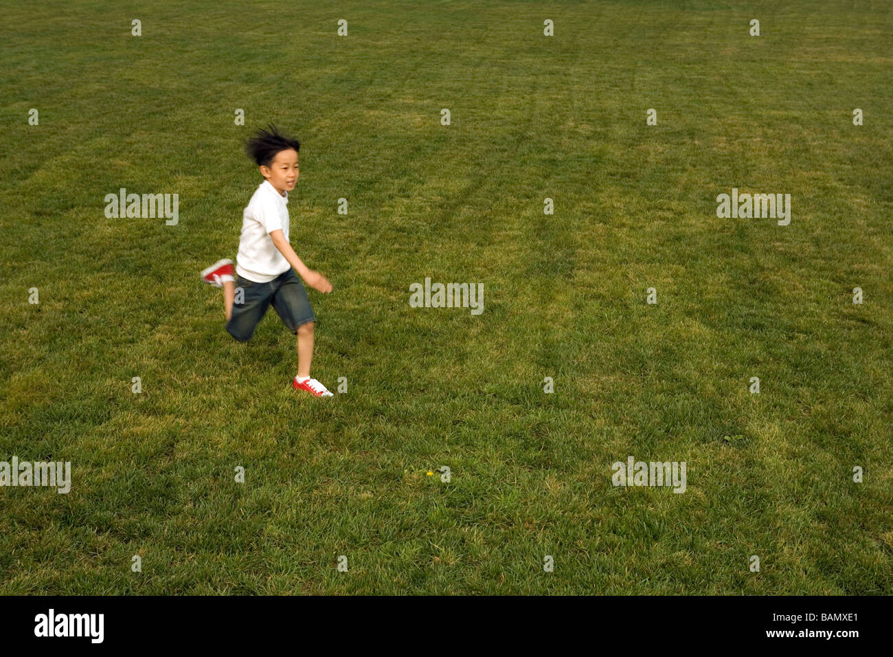Boy running across grass hi-res stock photography and images - Alamy
