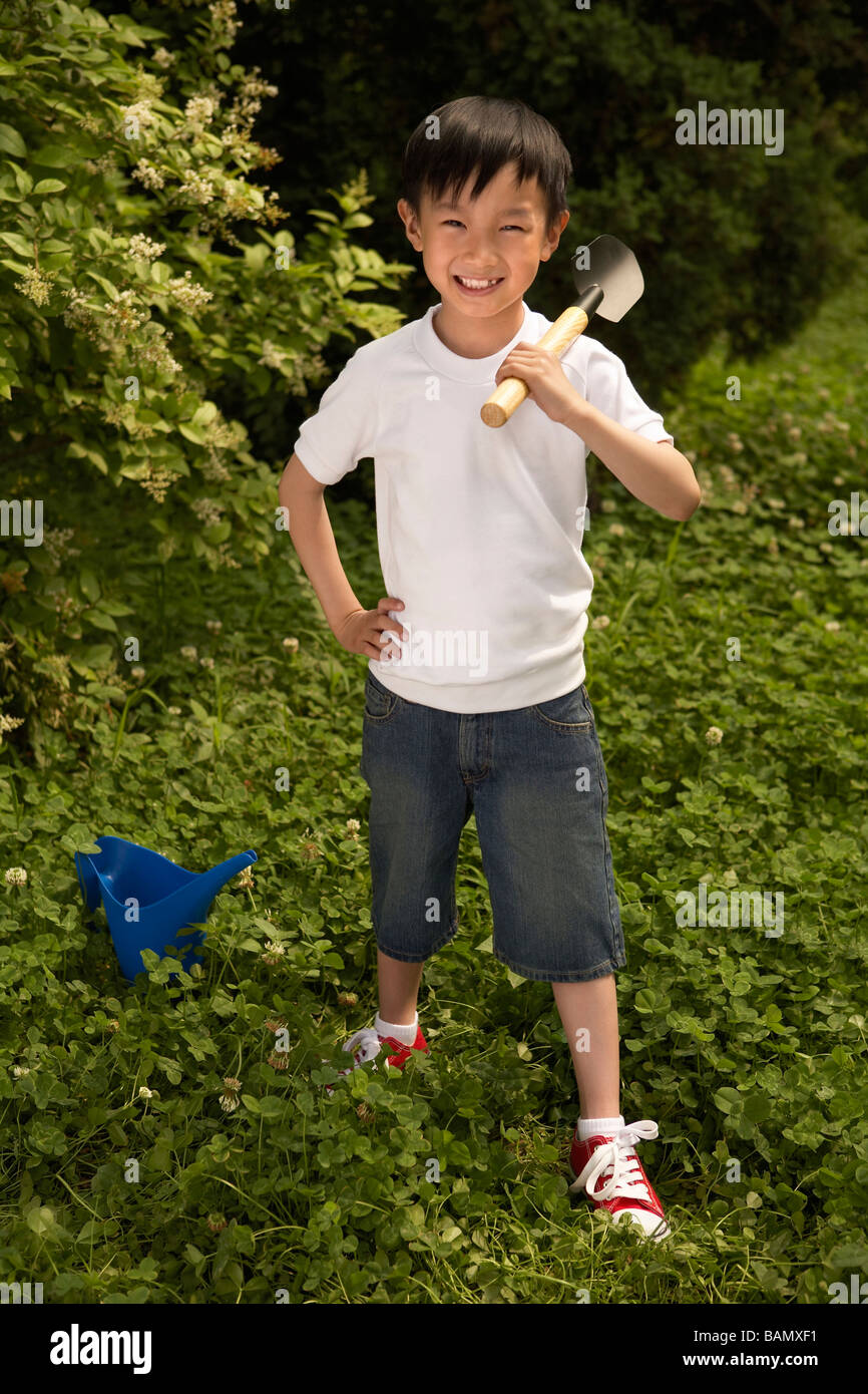Young Boy Holding Spade, Smiling Stock Photo - Alamy