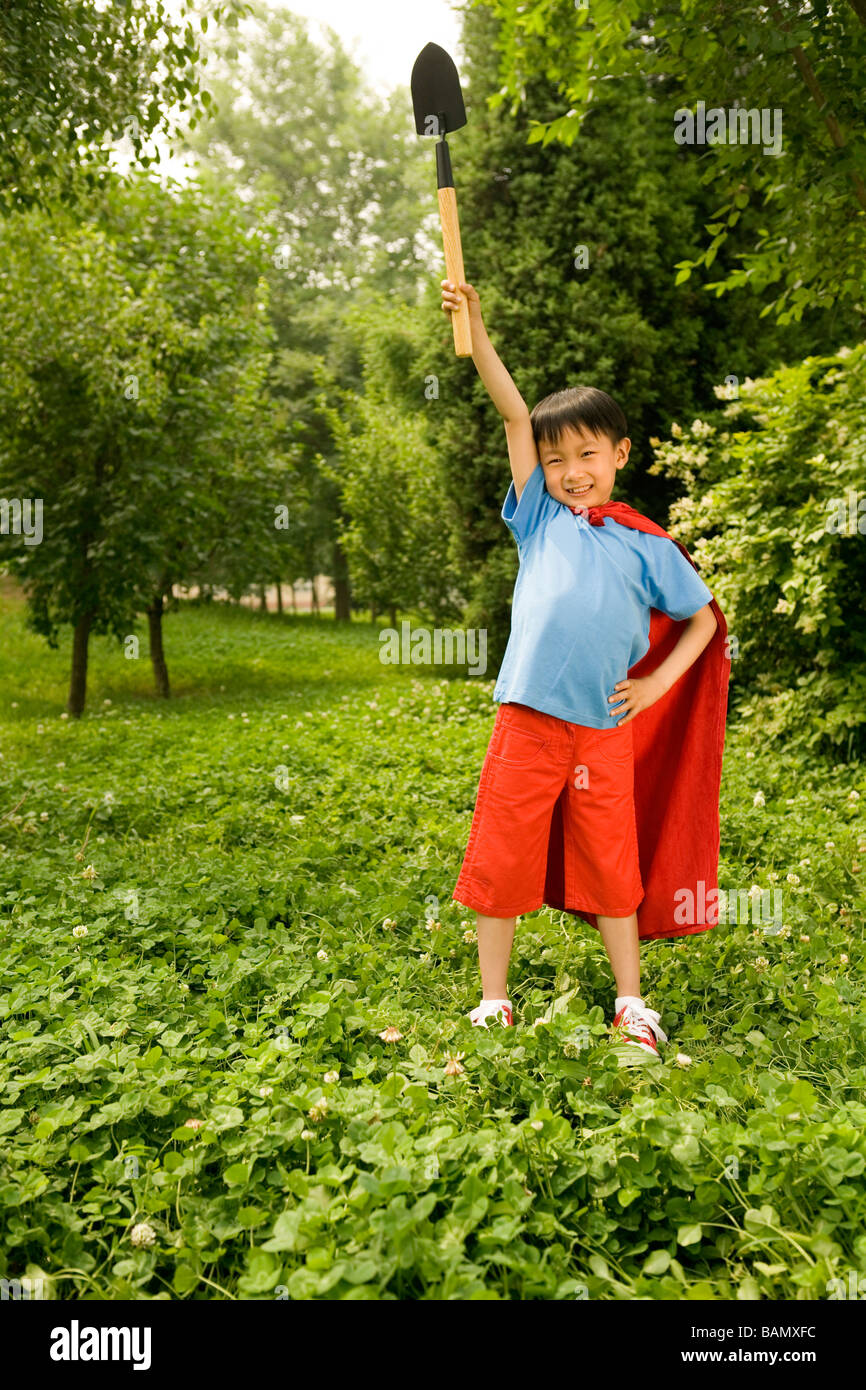 Boy Standing In Garden Holding Spade In The Air Stock Photo - Alamy