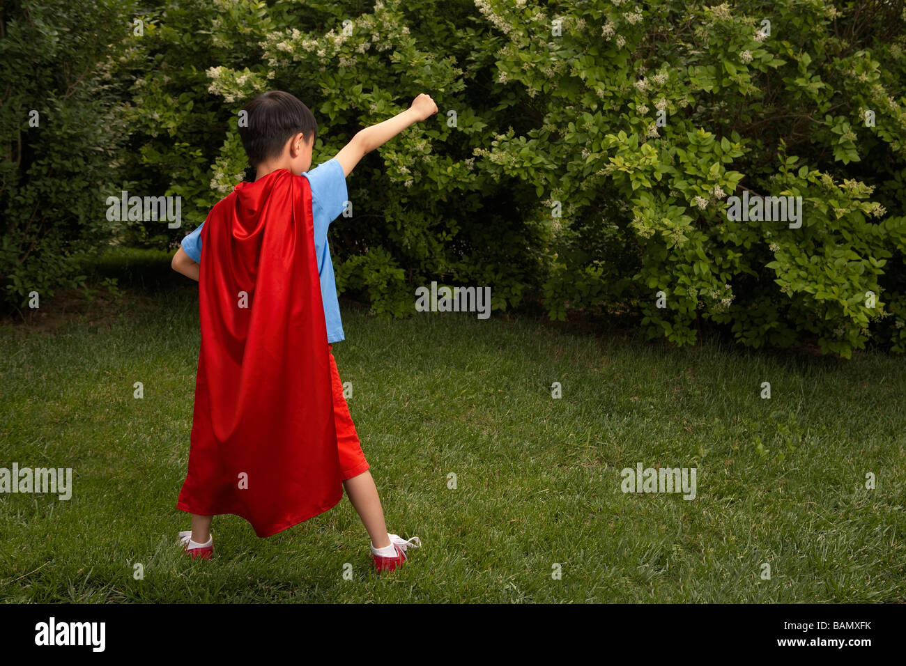 Boy In Red Cape Playing In Garden Stock Photo - Alamy