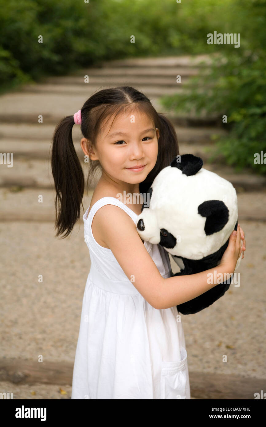 Young Girl Standing In Park Holding Panda Soft Toy Stock Photo - Alamy