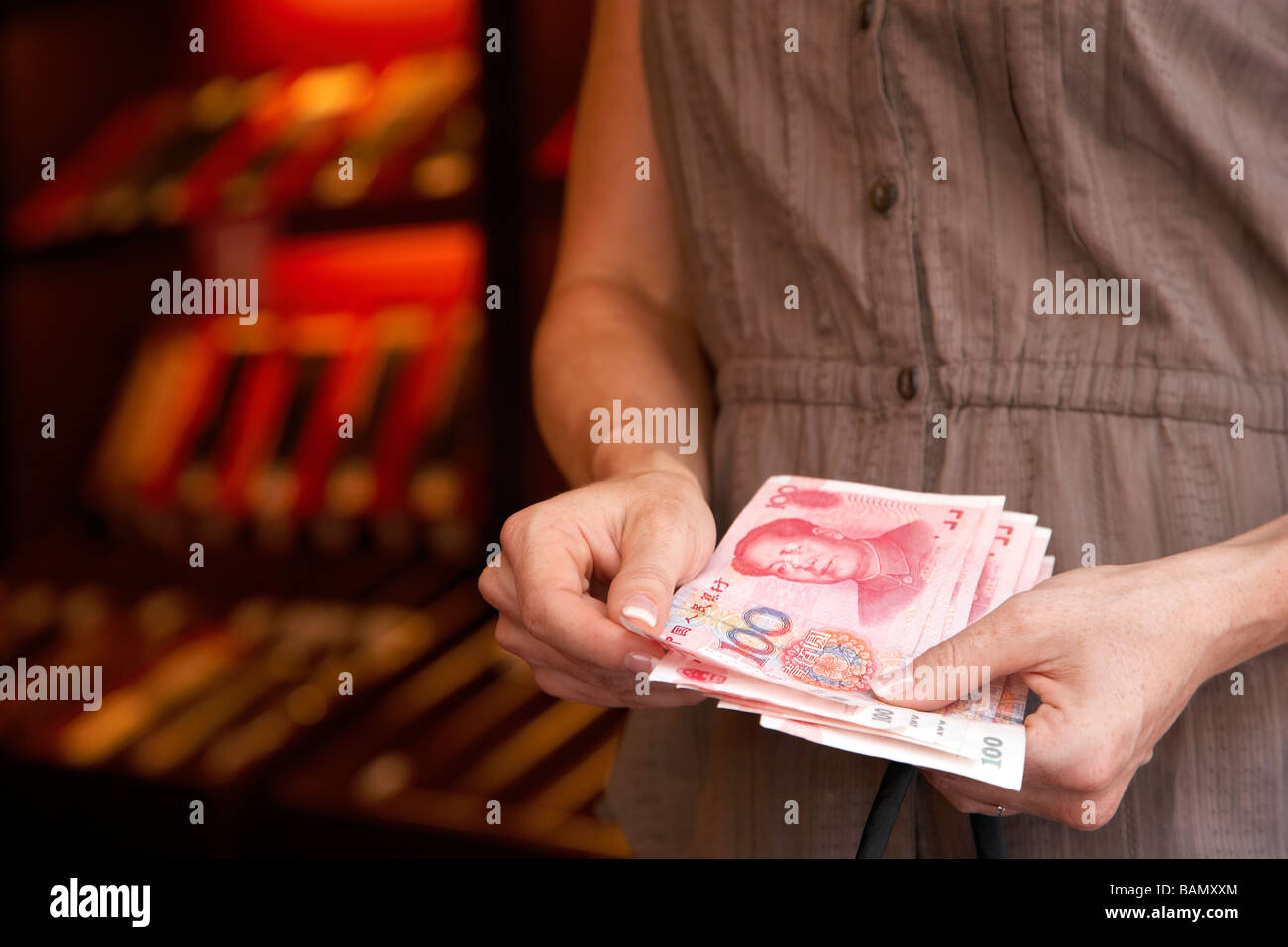 A tourist counts her Chinese currency on a shopping trip to Shanghai ...