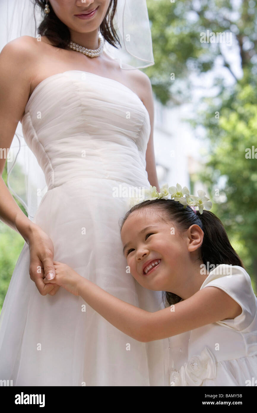 A young flower girl with the bride after a wedding Stock Photo - Alamy