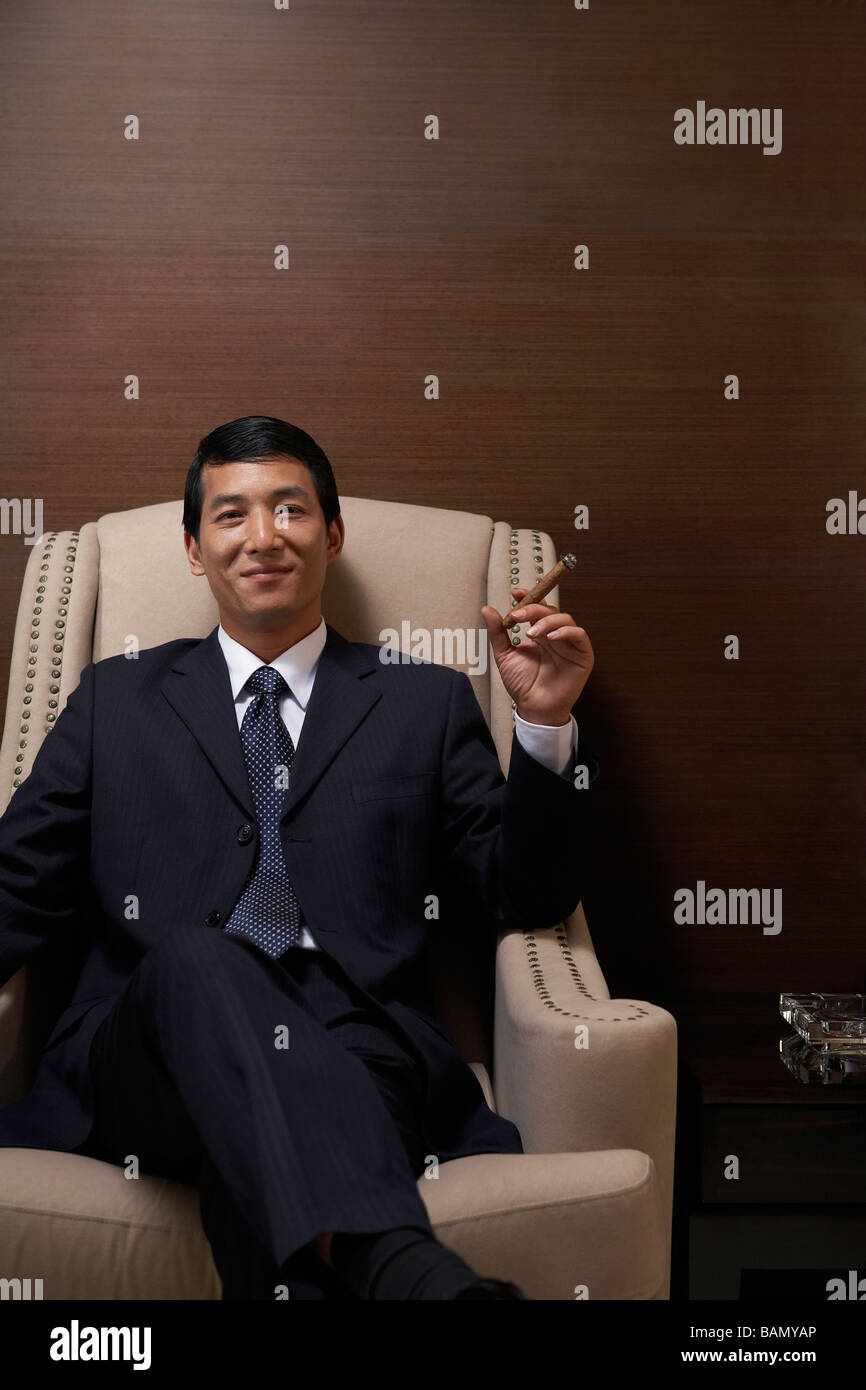 Successful businessman enjoys a cigar Stock Photo - Alamy