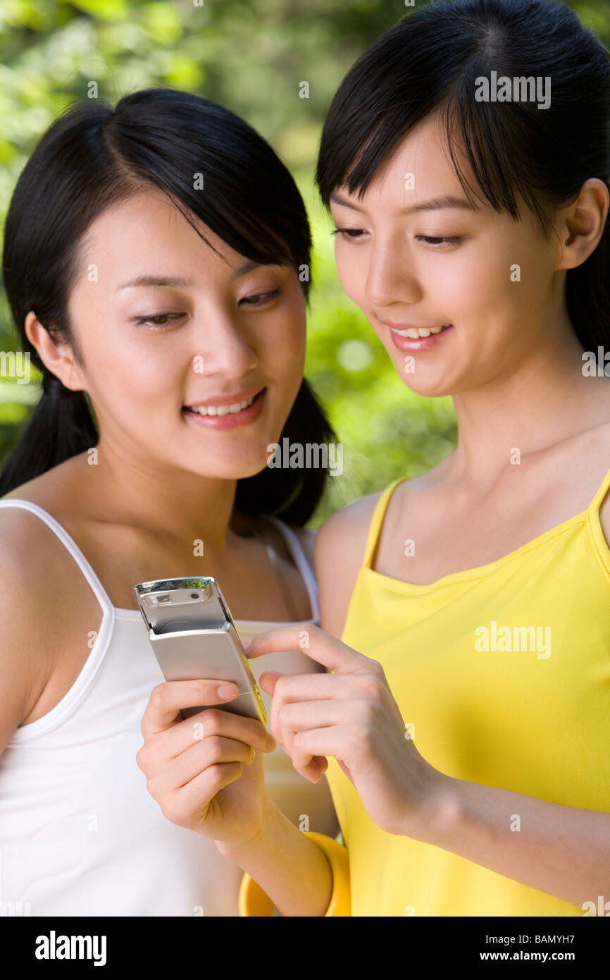 2 friends looking at phones hi-res stock photography and images - Alamy