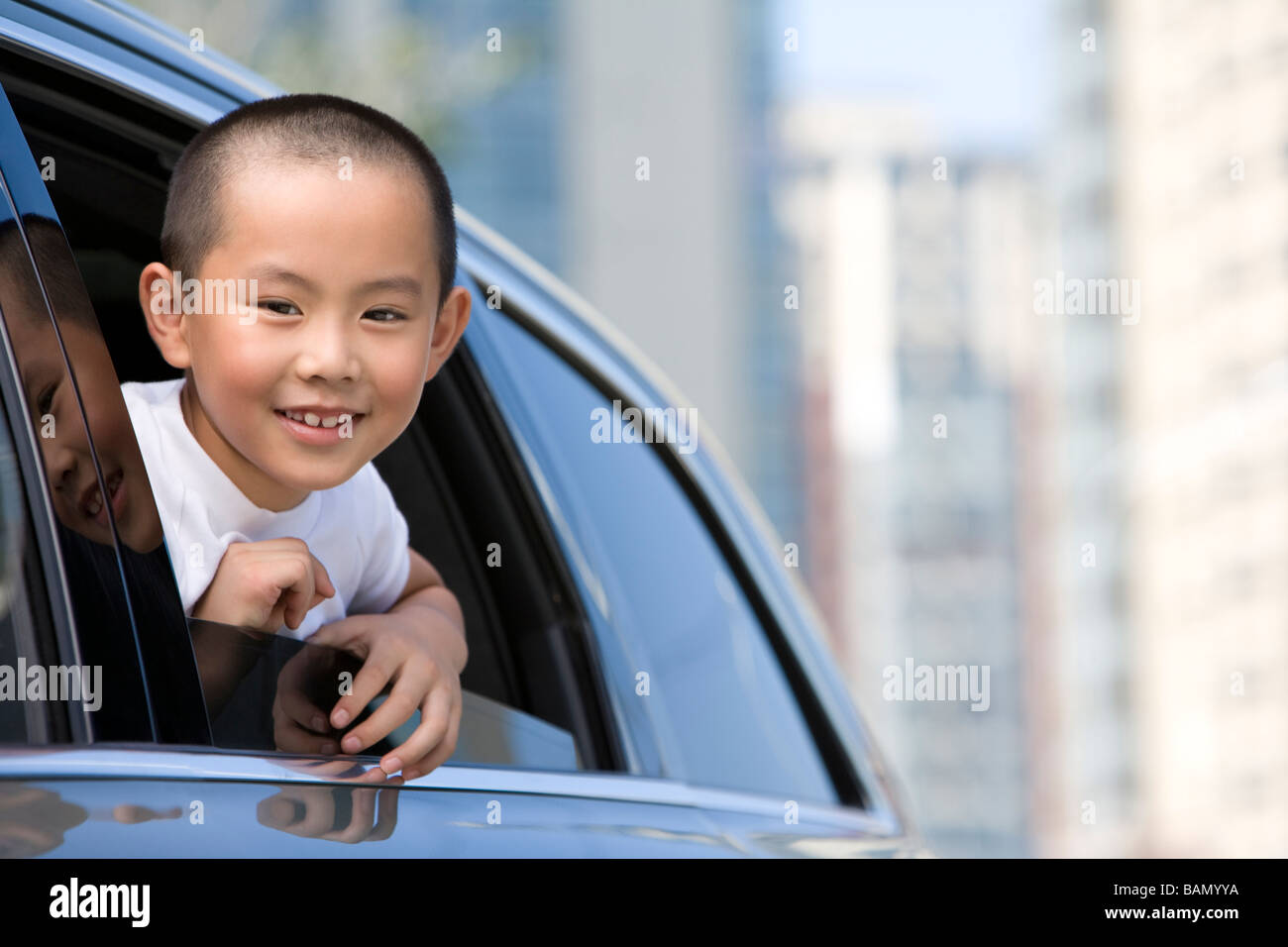 Young boy leaning out car window Stock Photo - Alamy
