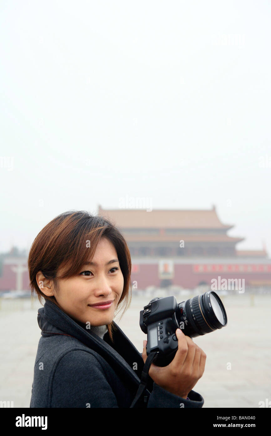 Portrait of a young woman holding camera, Tiananmen Square, Beijing ...