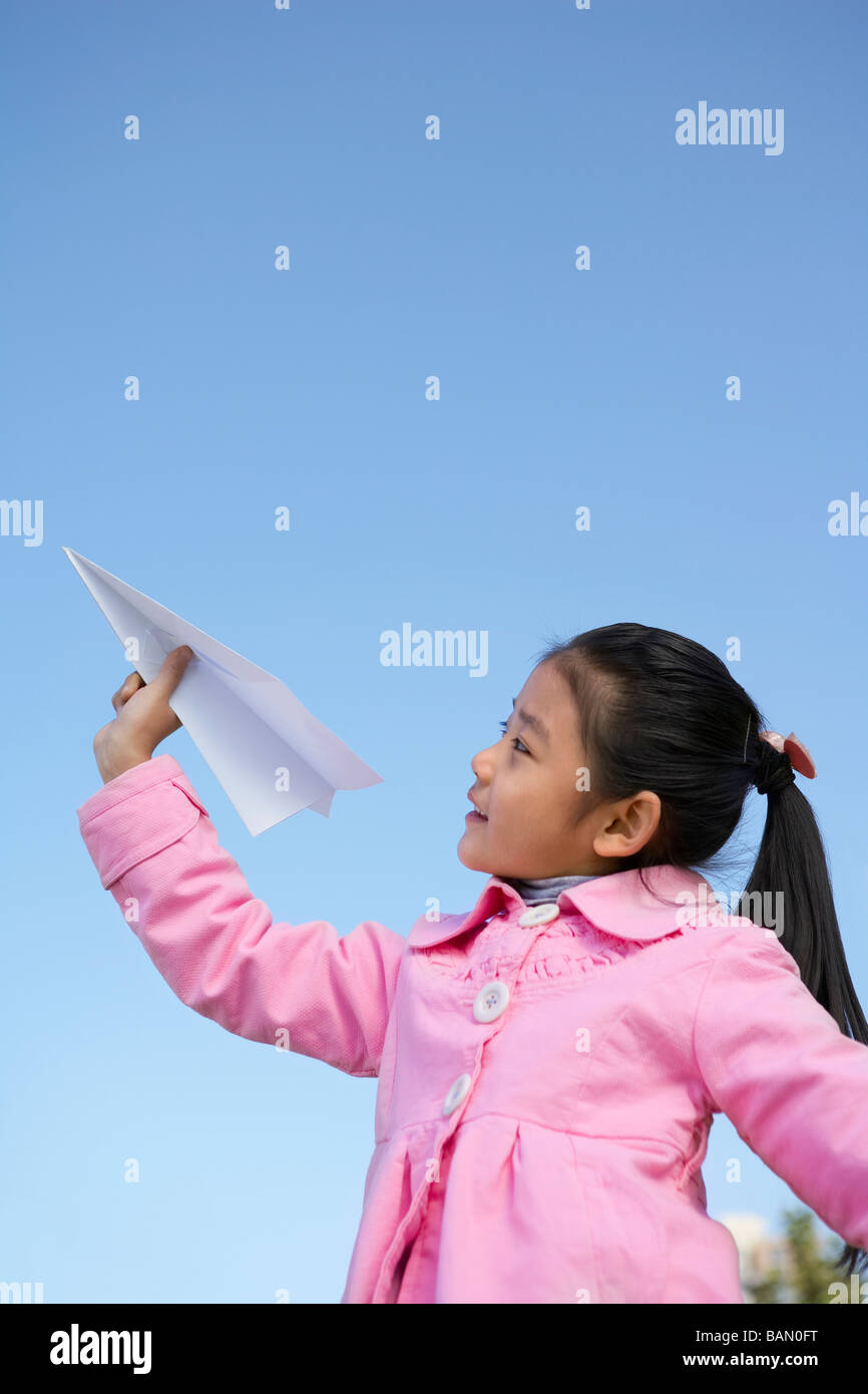 A young girl throwing a paper airplane Stock Photo - Alamy