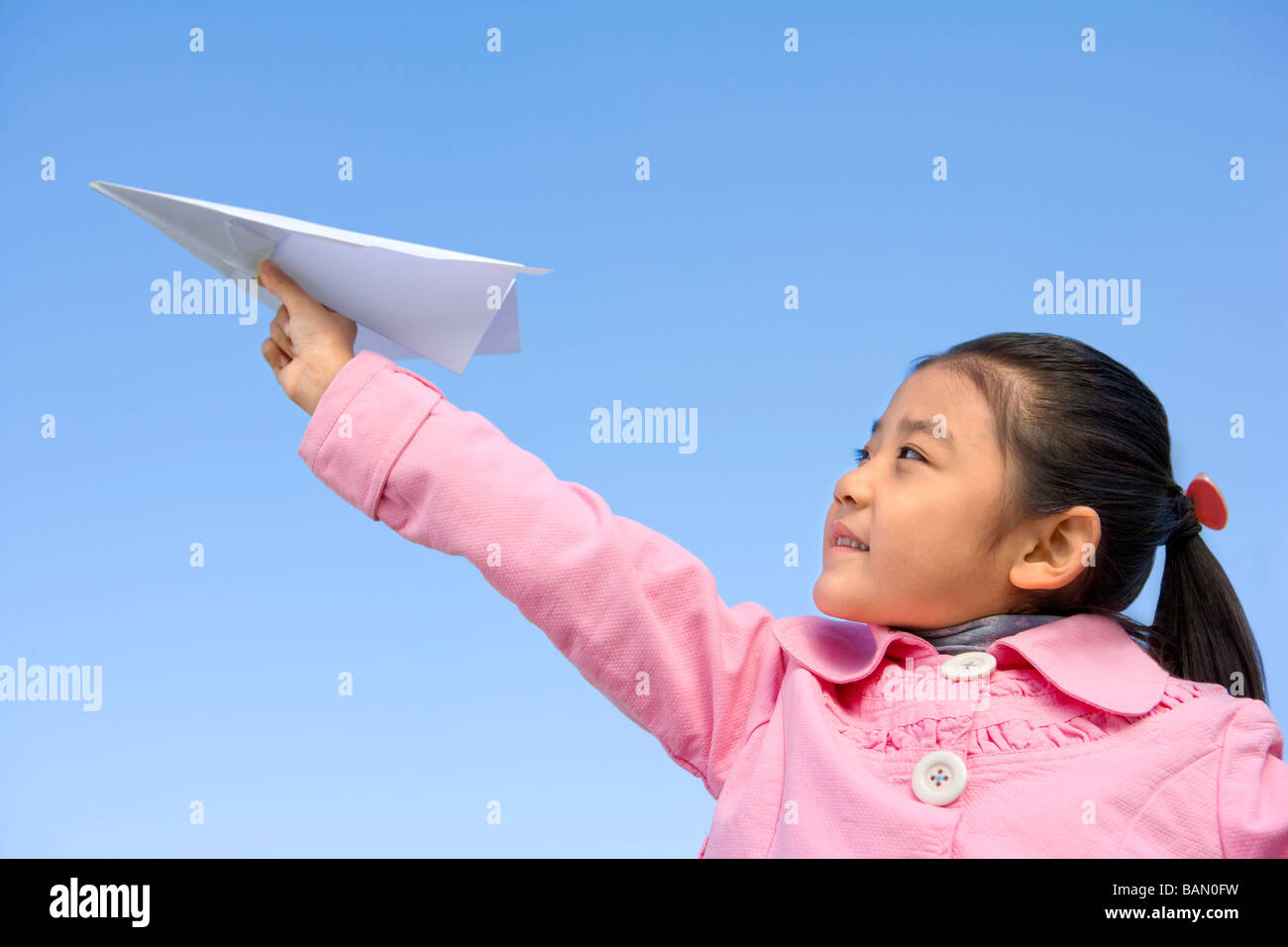 A young girl throwing a paper airplane Stock Photo - Alamy