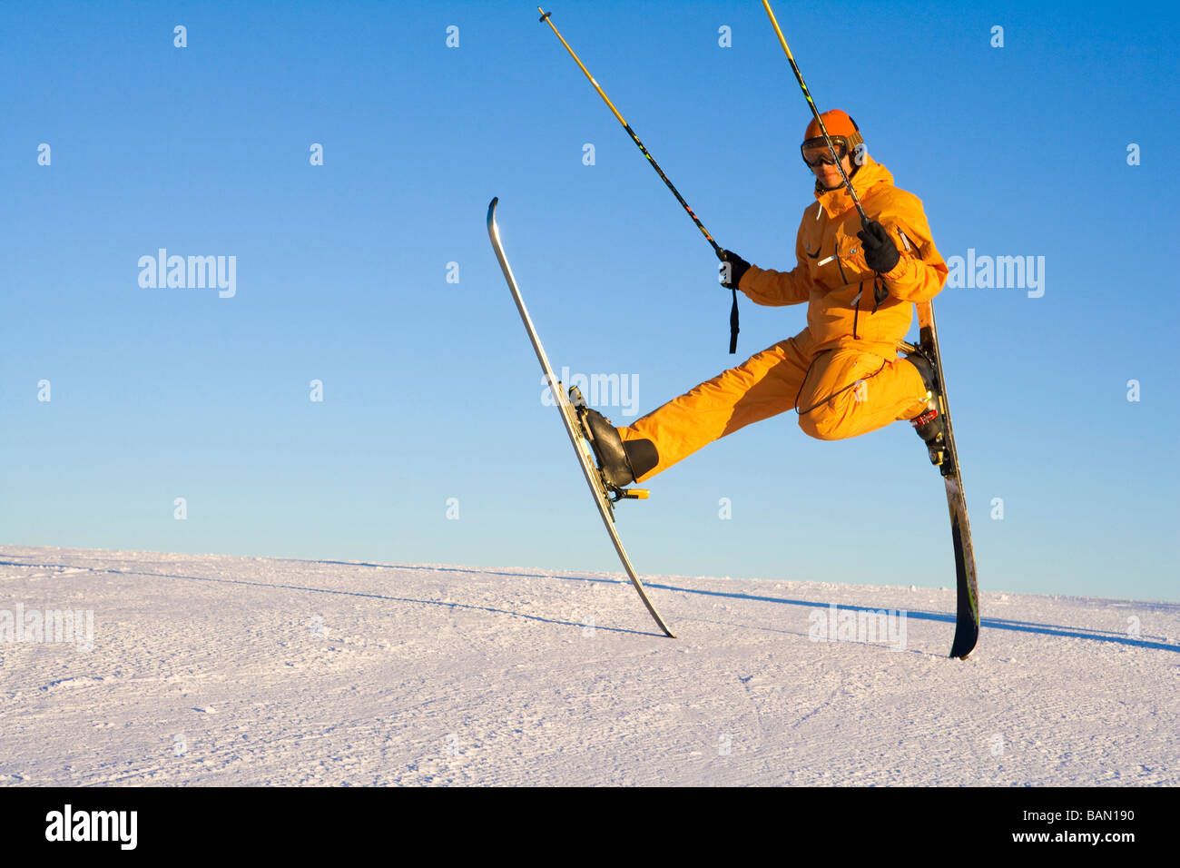 Young man playing around with ski equipment Stock Photo - Alamy