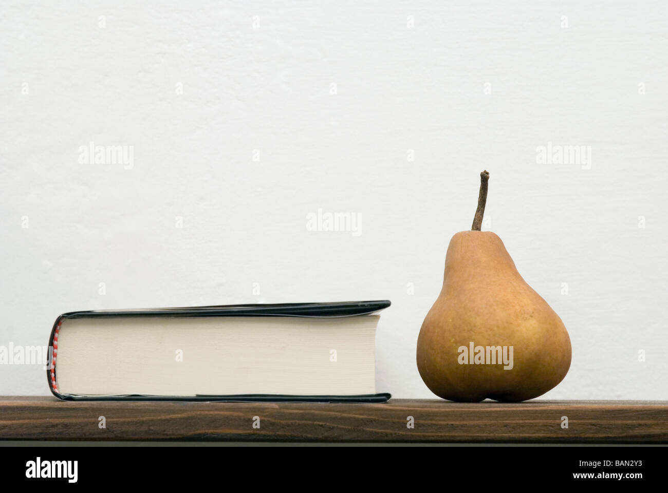 pear and book on shelf Stock Photo - Alamy