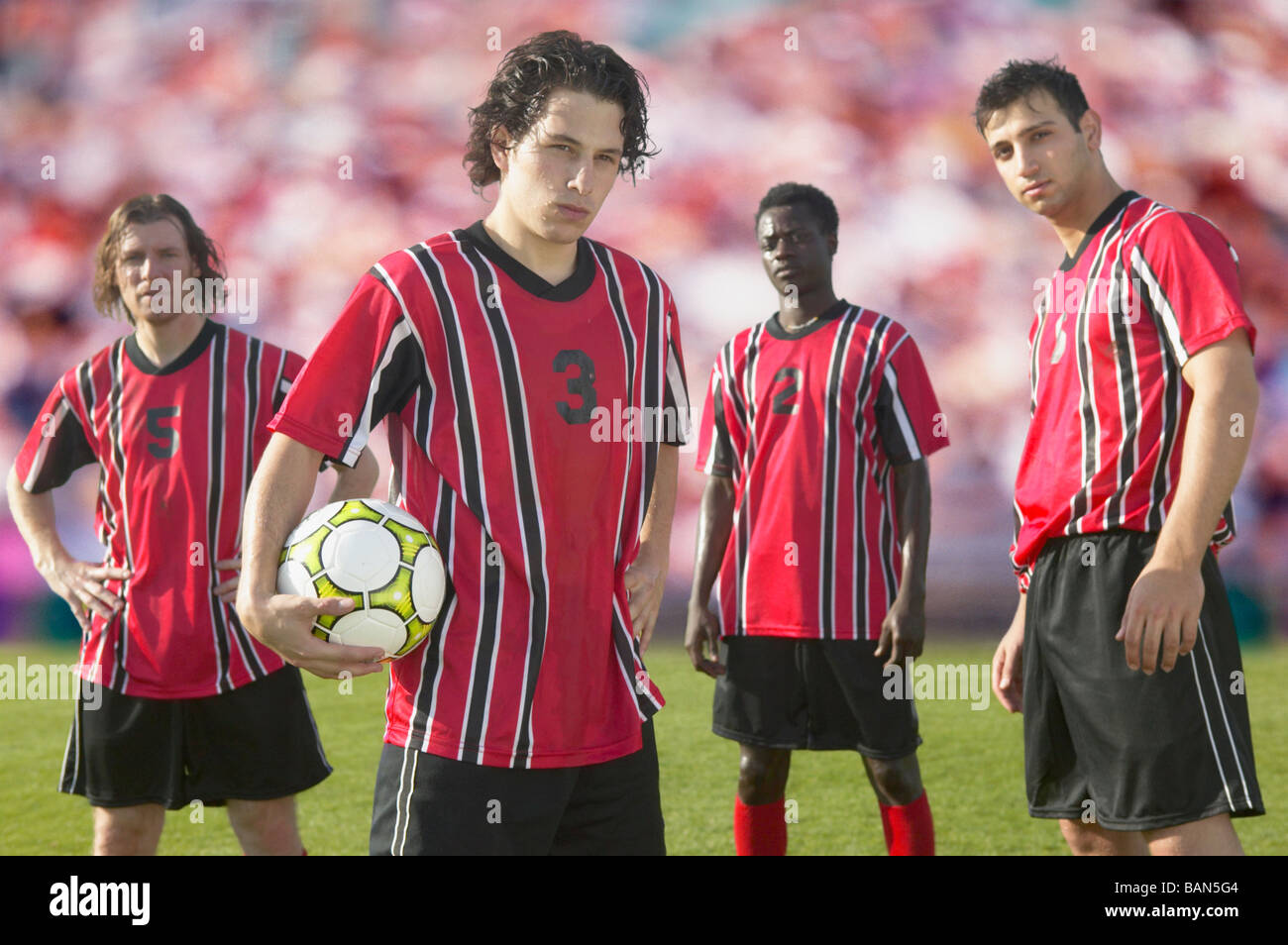 Soccer players posing for the camera on pitch Stock Photo - Alamy