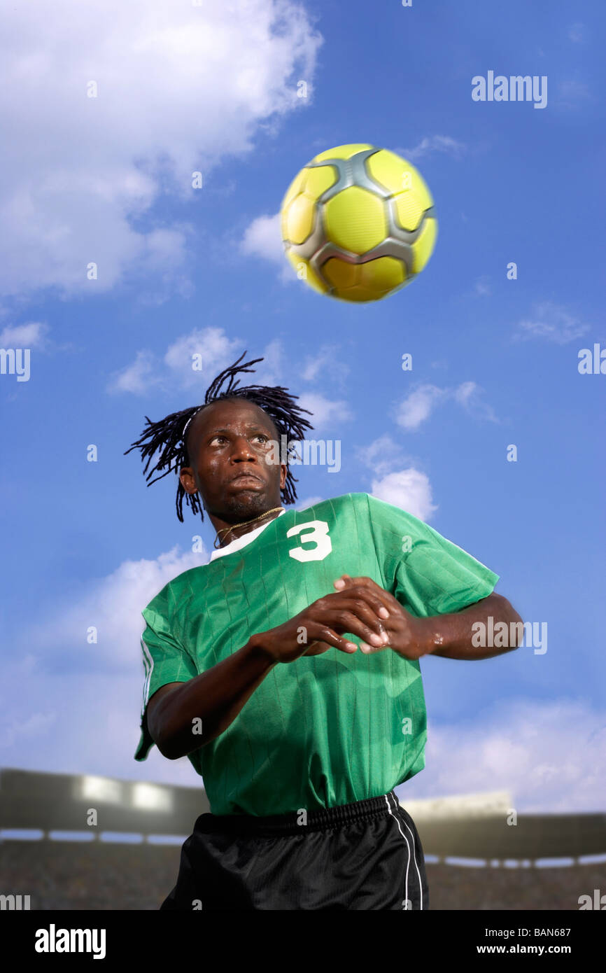 Male soccer player headering the ball Stock Photo - Alamy