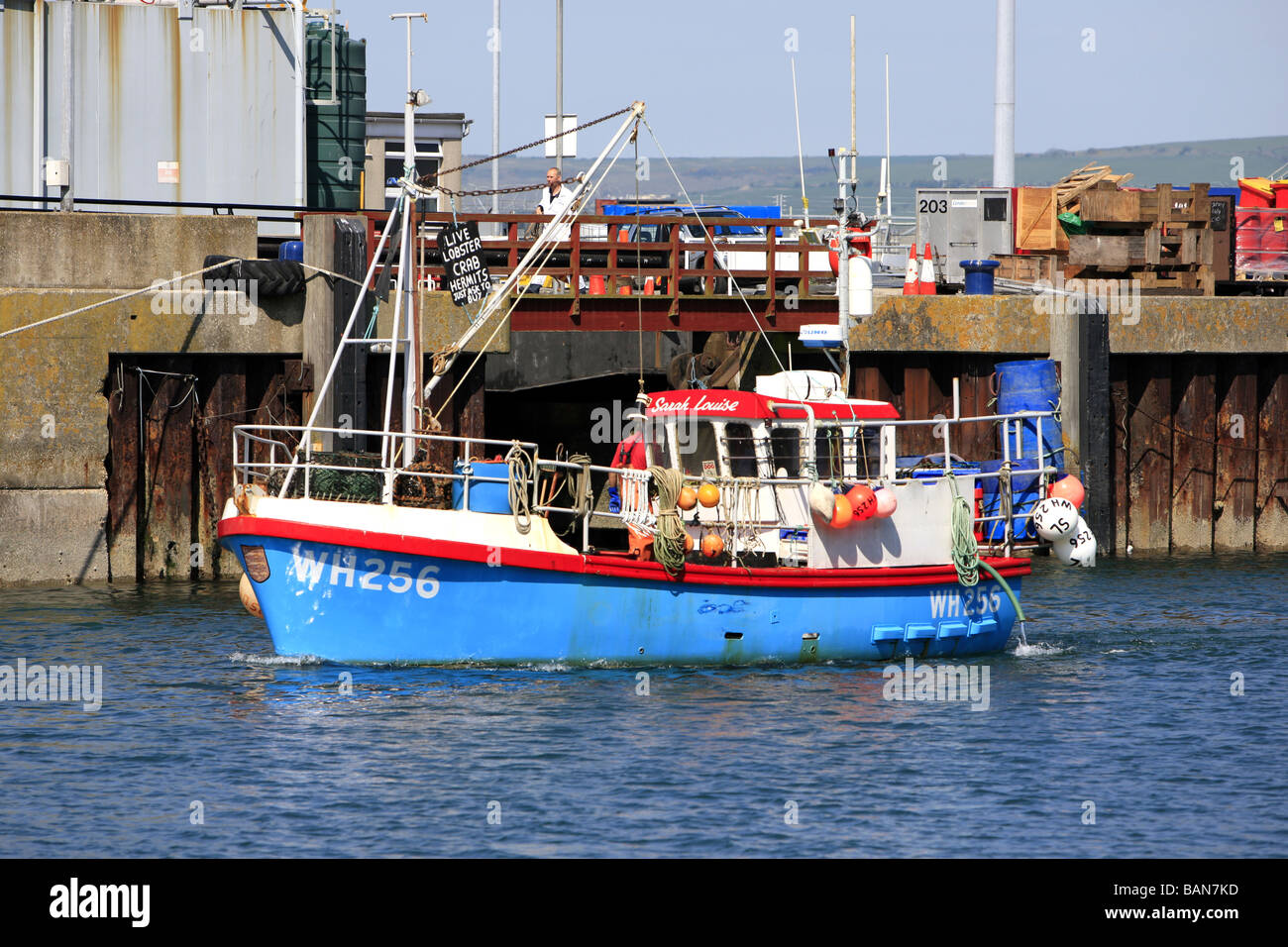 A small shell fish fishing boat slowly motors into Weymouth Harbour to ...