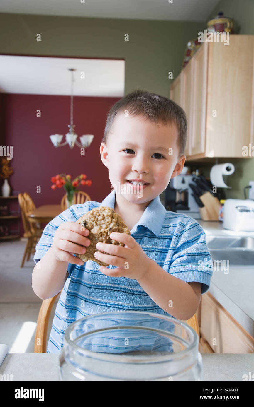 Young boy taking cookie from cookie jar Stock Photo - Alamy