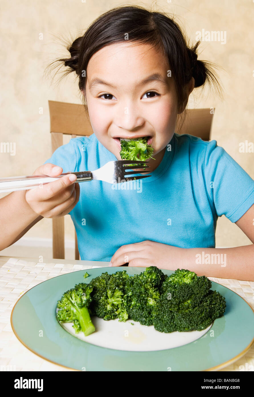 Young Asian girl eating broccoli Stock Photo - Alamy